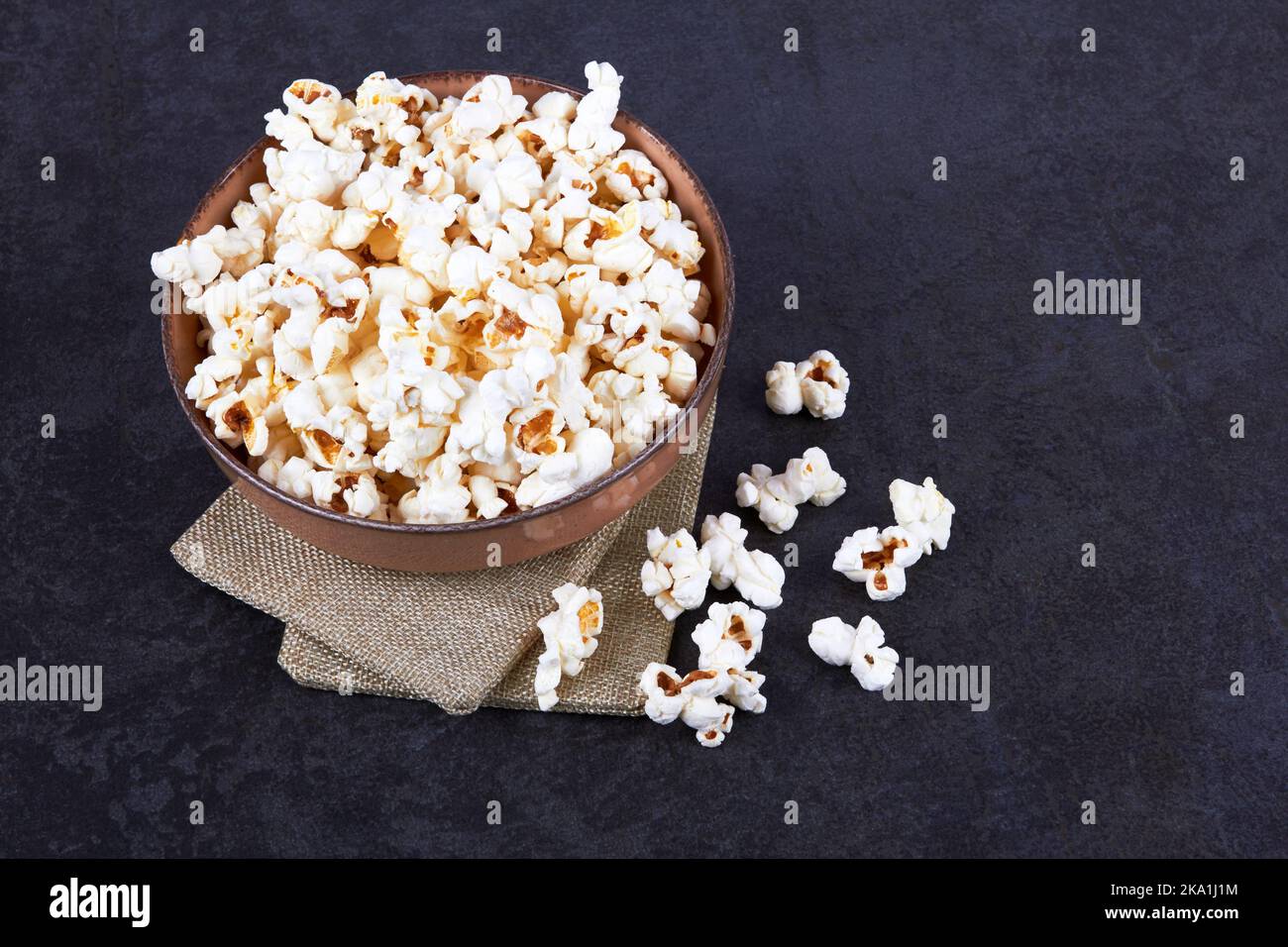 Popcorn in bowl food on black stone background Stock Photo - Alamy