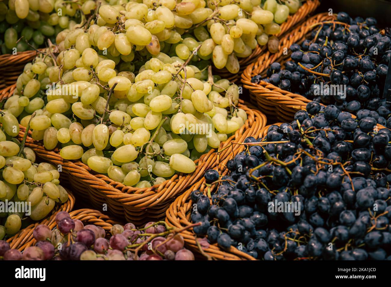 Baskets with different types of grapes on a supermarket showcase Stock ...