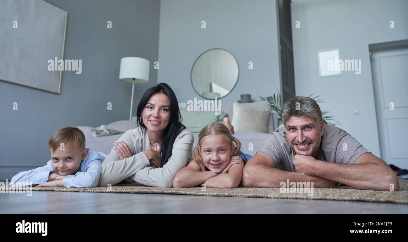 Photo of four members adopted family lying floor toothy smiling fluffy ...