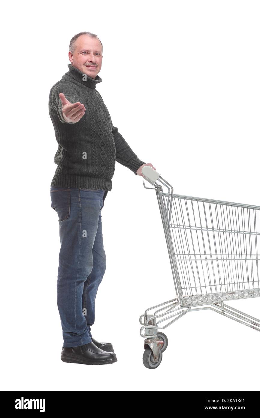 Side view of happy young man with shopping trolley and smiling at ...