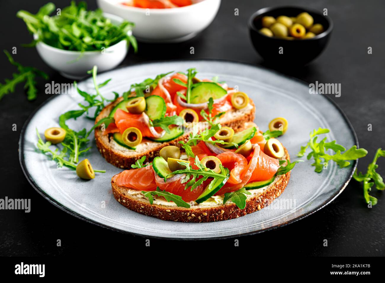Toasts with salted salmon, arugula, green olives and cucumber Stock ...