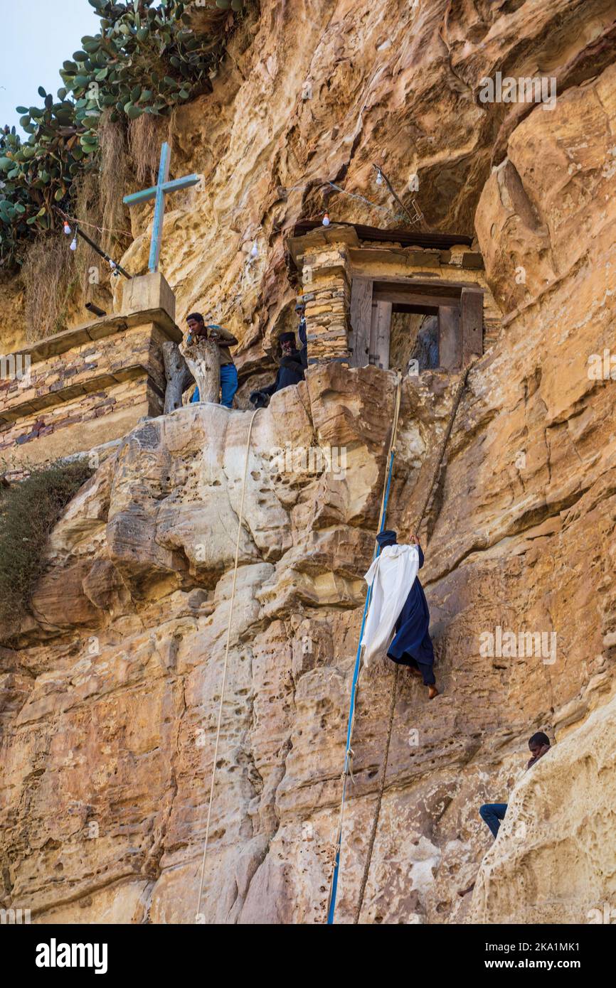 DEBRE DAMO, TIGRAY REGION, ETHIOPIA - JANUARY 25, 2019: Monk climbing a ...