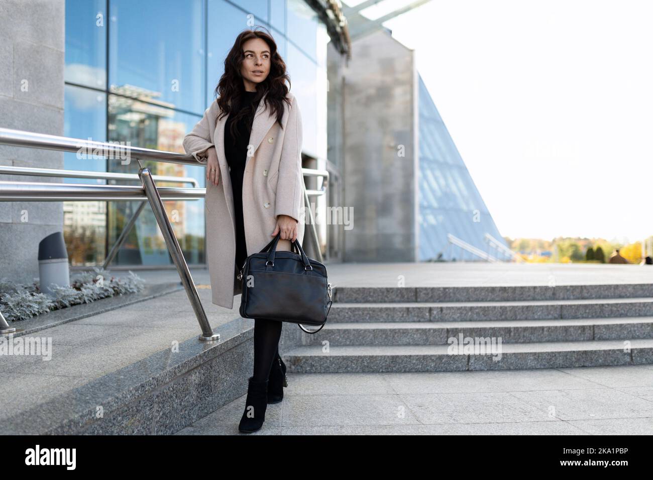 stylish businesswoman with a briefcase in her hands on the background ...