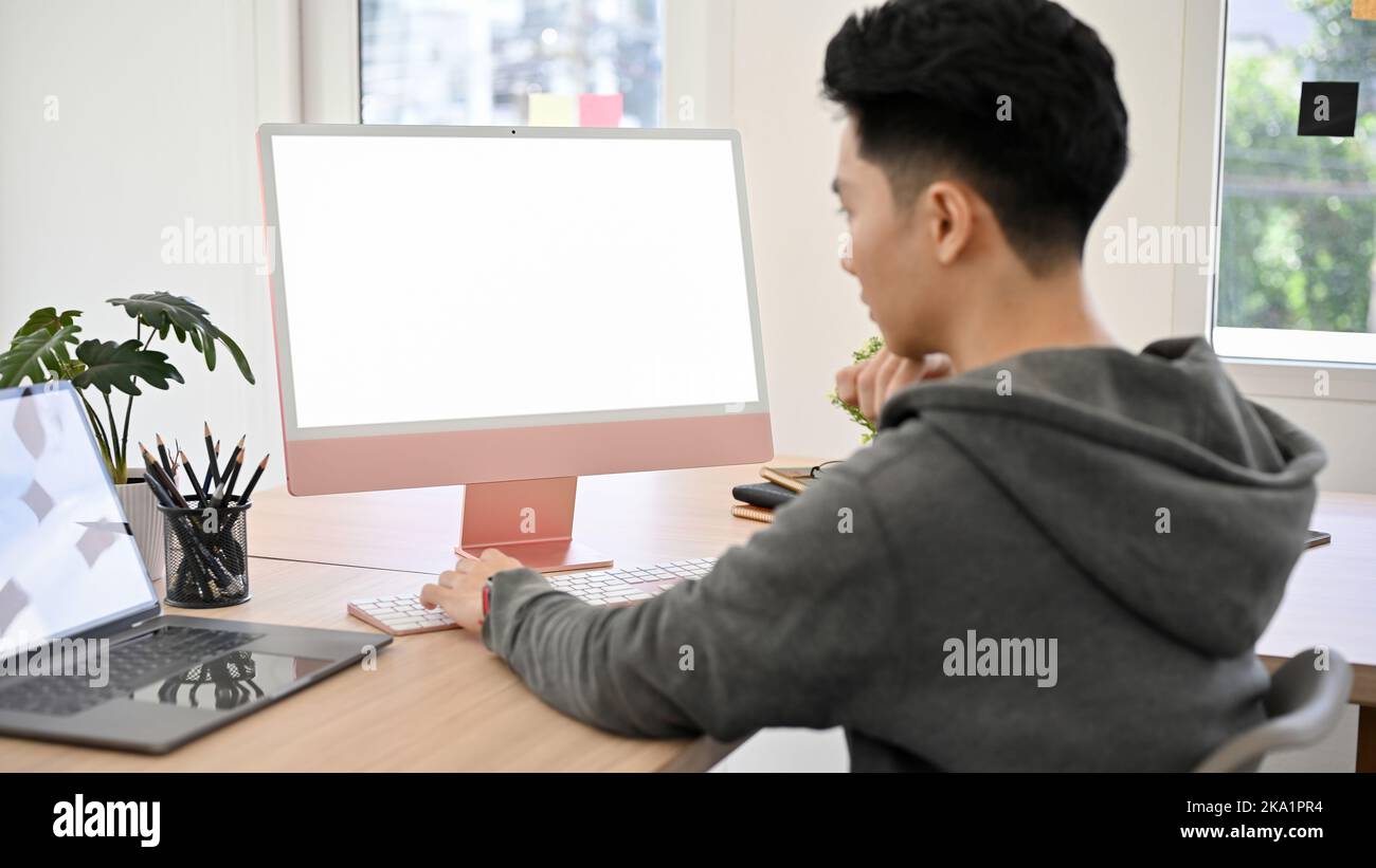 Smart and hipster young Asian male programmer or office worker working ...