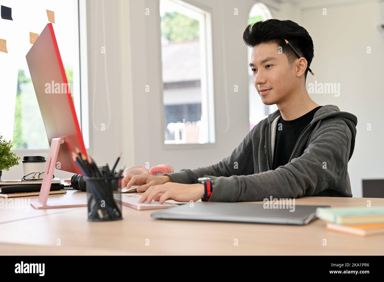 Smart young Asian male programmer or office employee in casual clothes ...