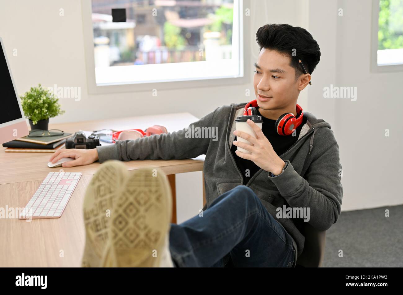 Hipster and chill young Asian male programmer or web developer enjoys ...