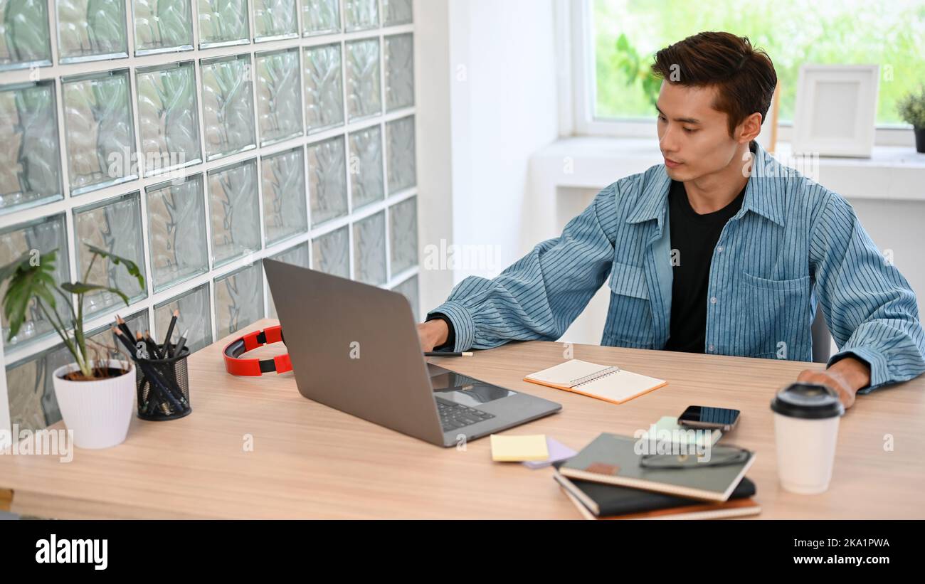 Handsome and smart millennial Asian male programmer or freelancer in ...