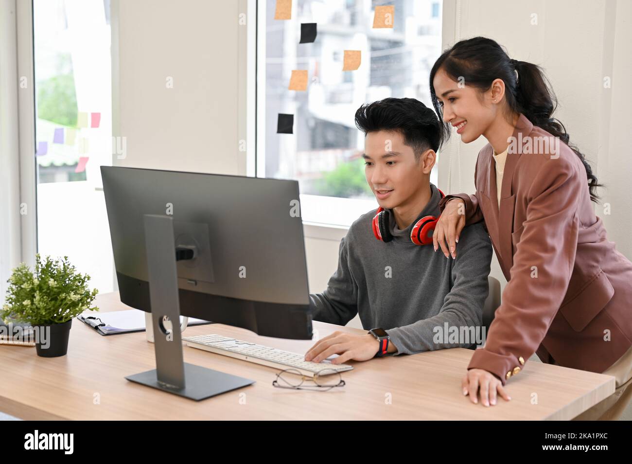 Smart And Handsome Young Asian Male Programmer Or Developer Working With His Female Manager To