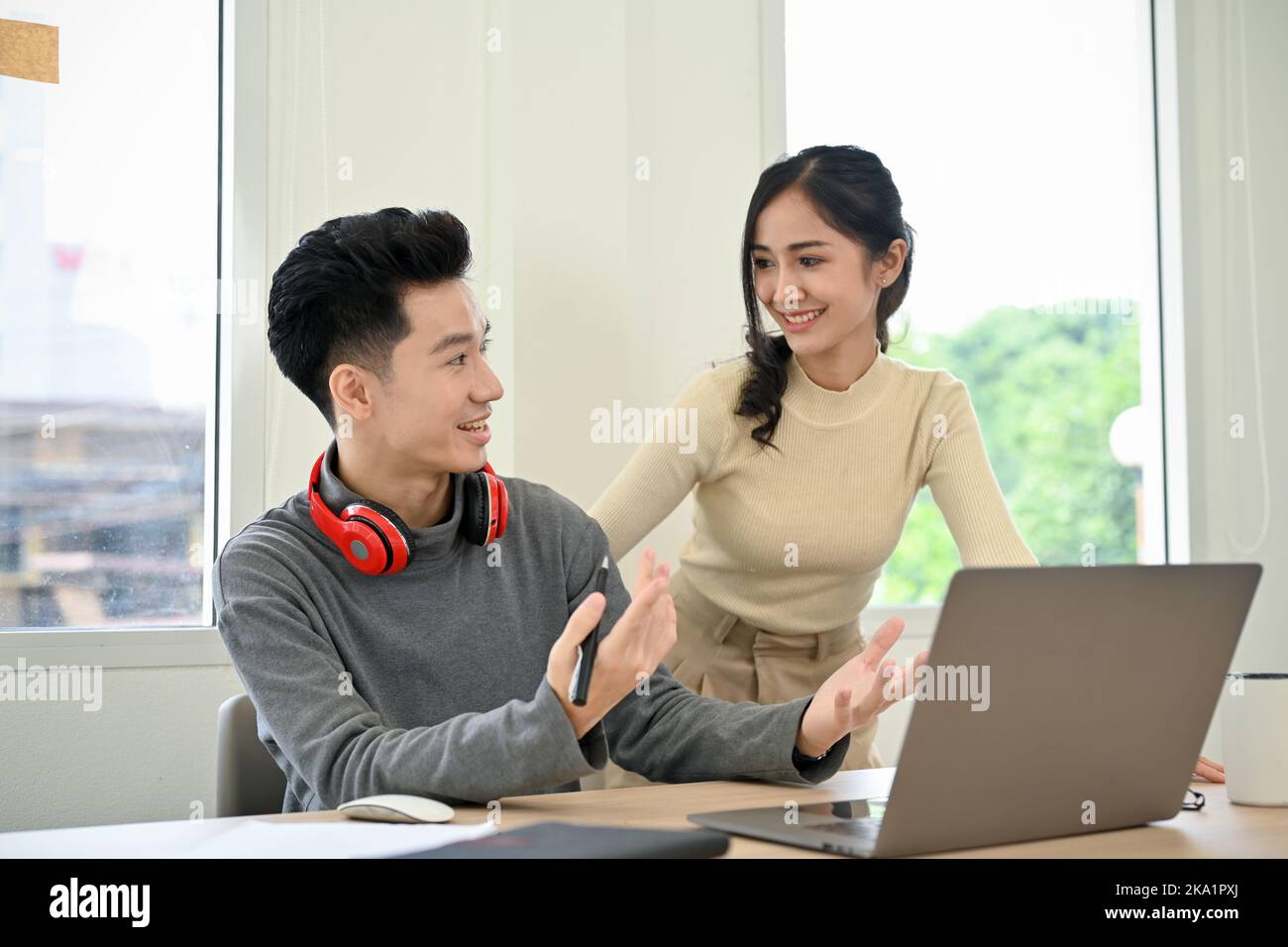 Cheerful and talented young Asian male and female office employees ...