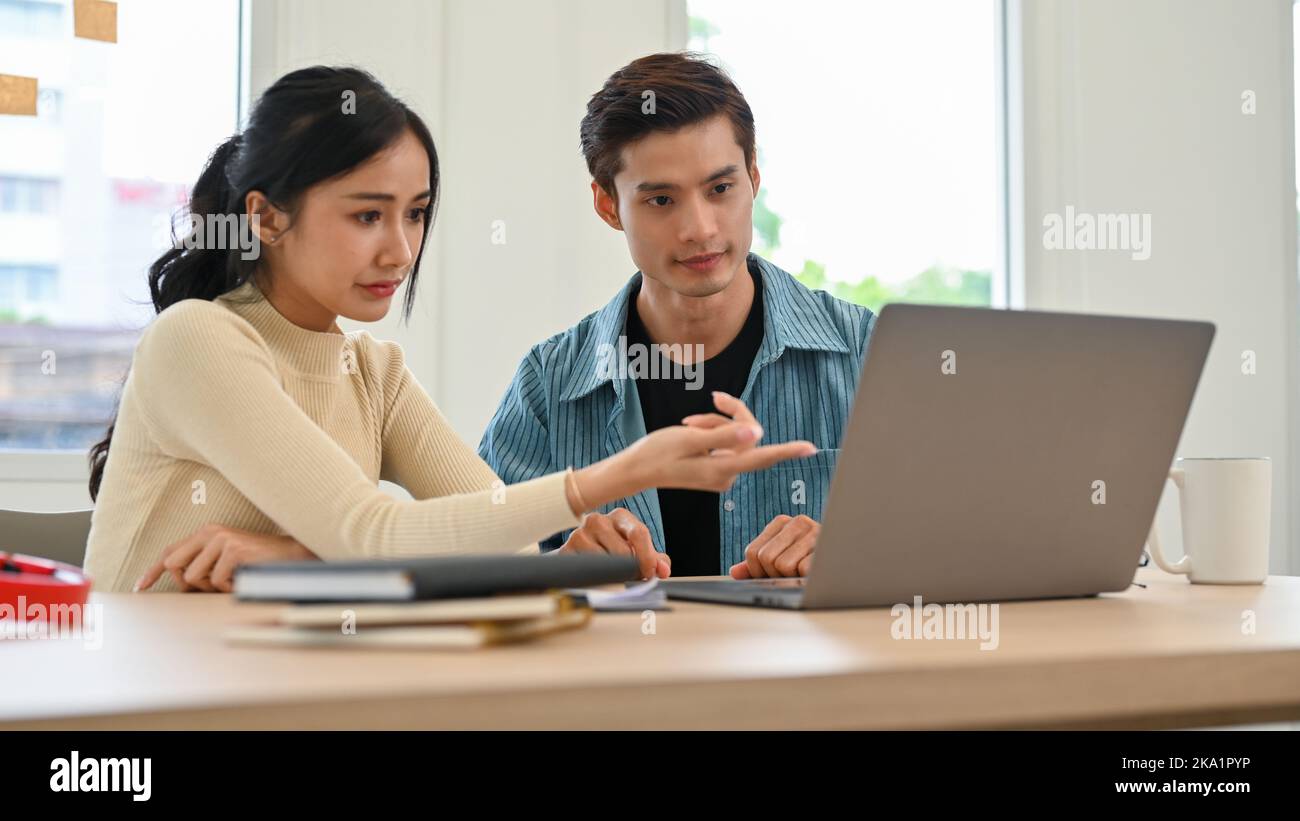 Two professional young Asian business startup workers focused on ...