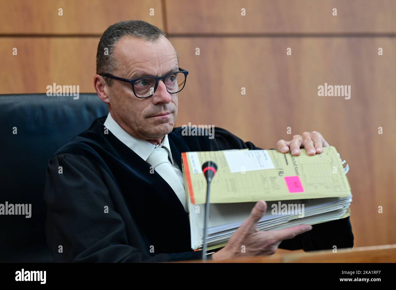 Kassel, Germany. 31st Oct, 2022. Presiding Judge Jürgen Dreyer holds up ...