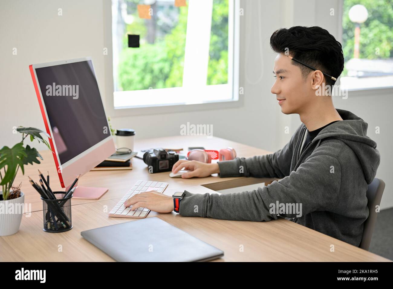 side view, Smart young Asian male office worker or programmer in casual ...
