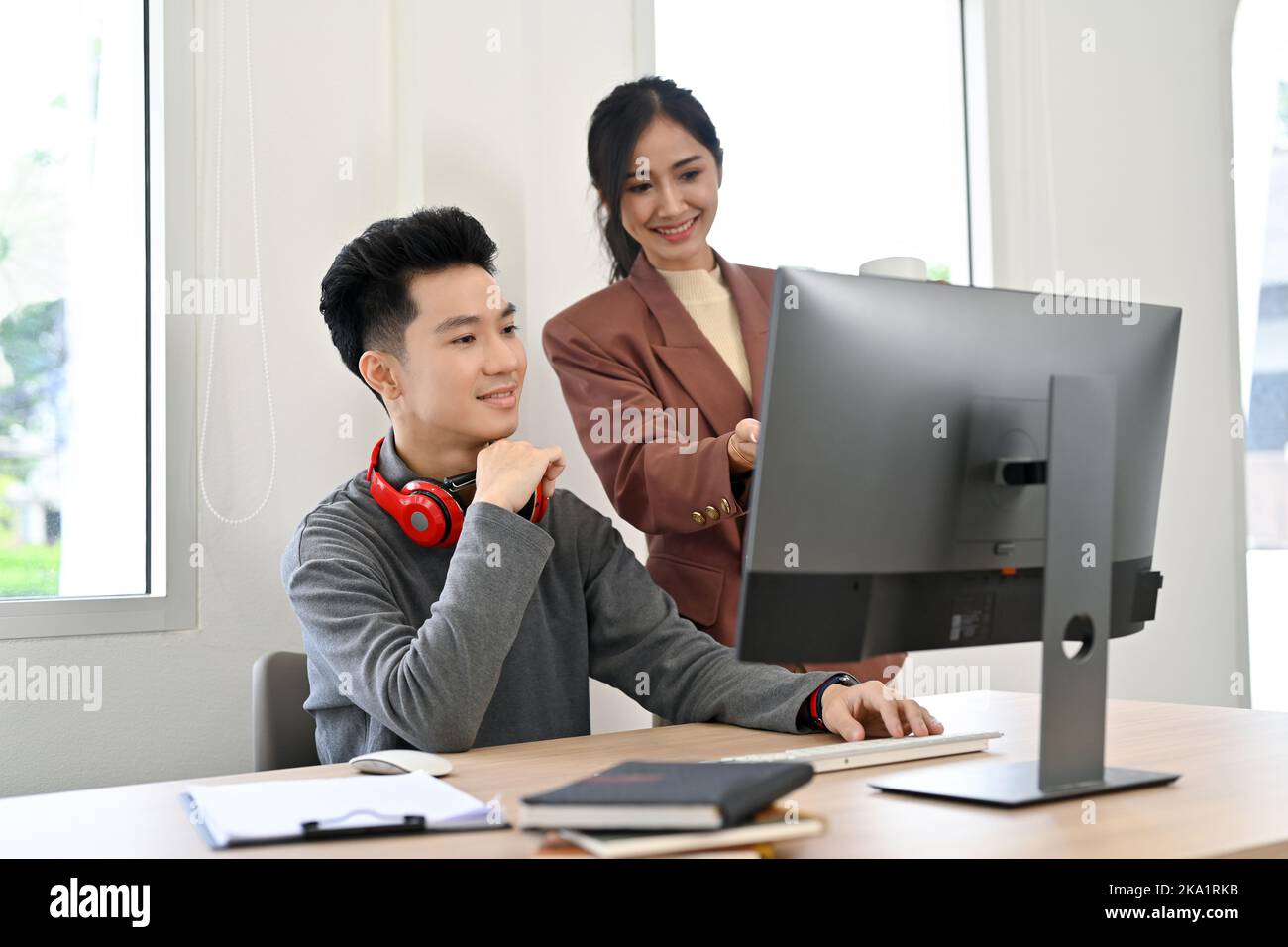 Smart and handsome young Asian male programmer or office worker working ...