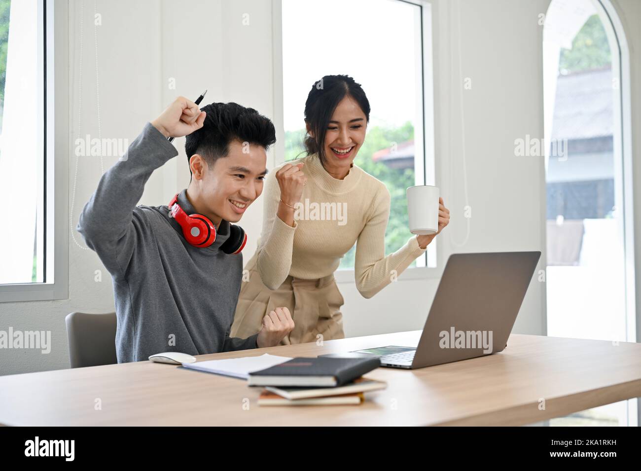 Happy and cheerful young Asian businesswoman and businessman ...