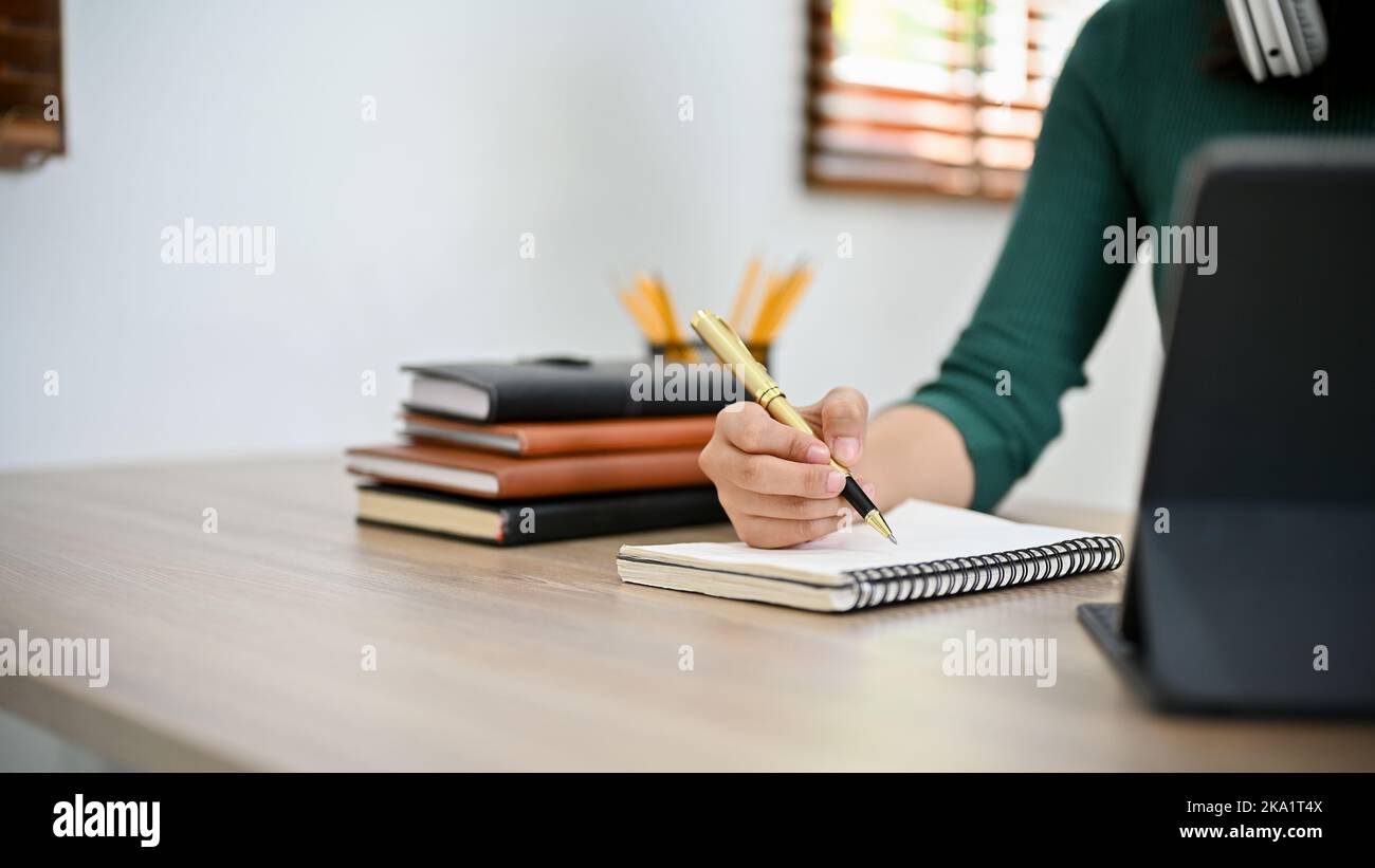 Female college student doing homework, writing or taking notes on her ...