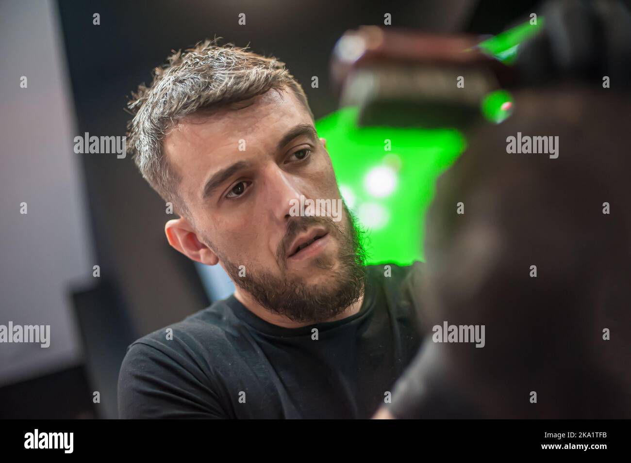 Modern urban hairdresser cut and adjusts the hairstyle in professional ...