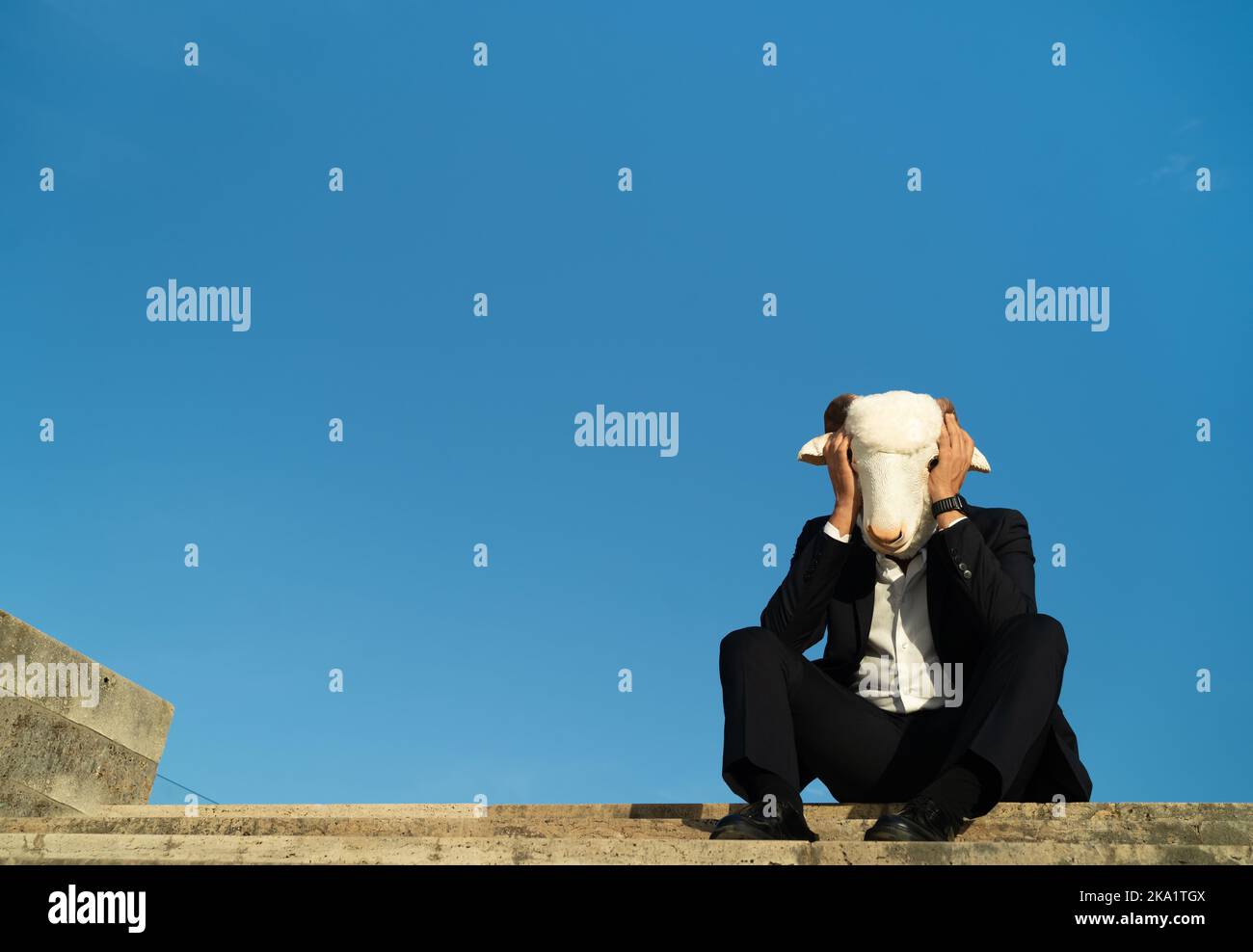 Sheep-headed businessman sitting on a ladder with his hands on his head ...