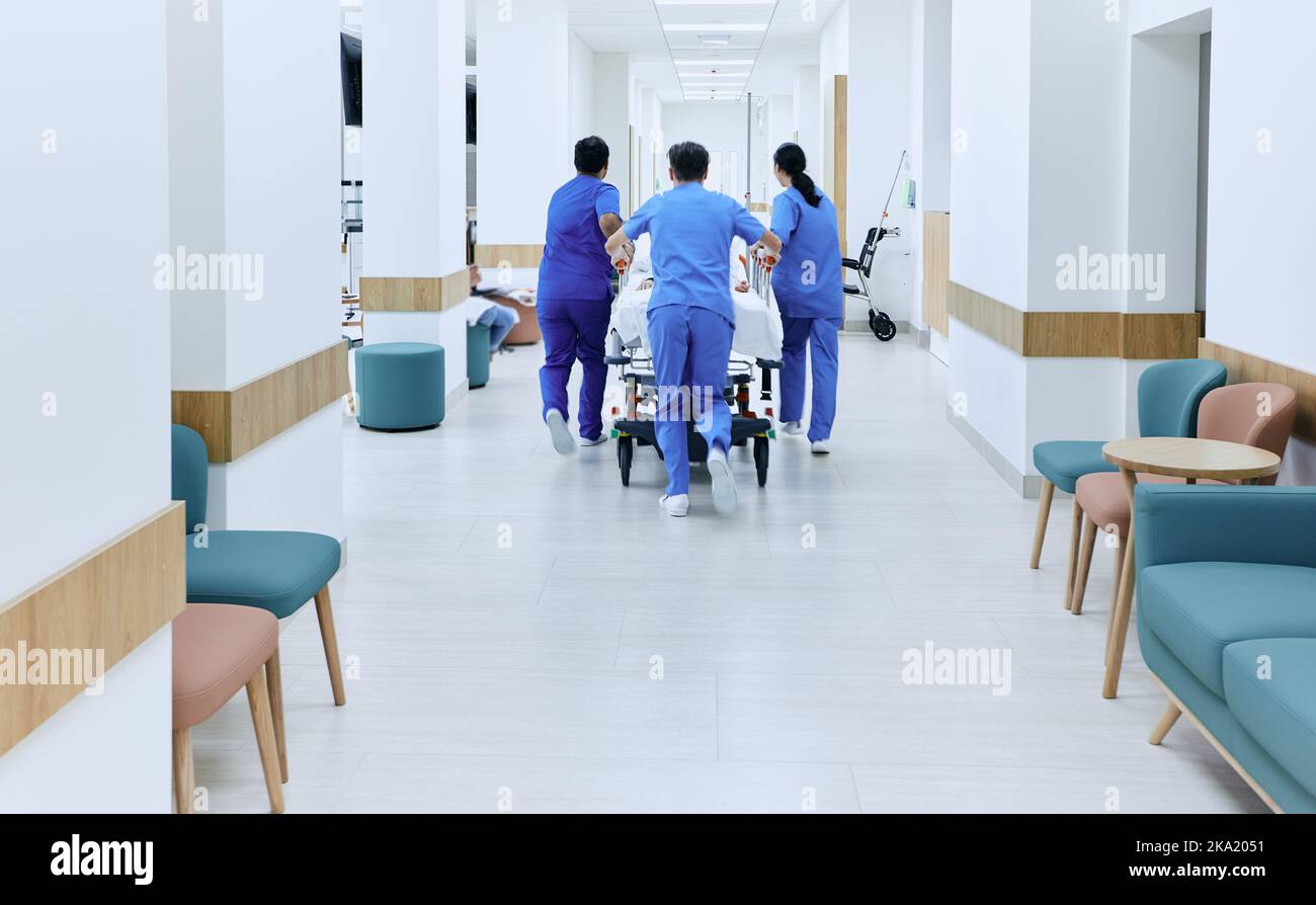 hospital care team hastily wheeling patient on medical gurney at ...