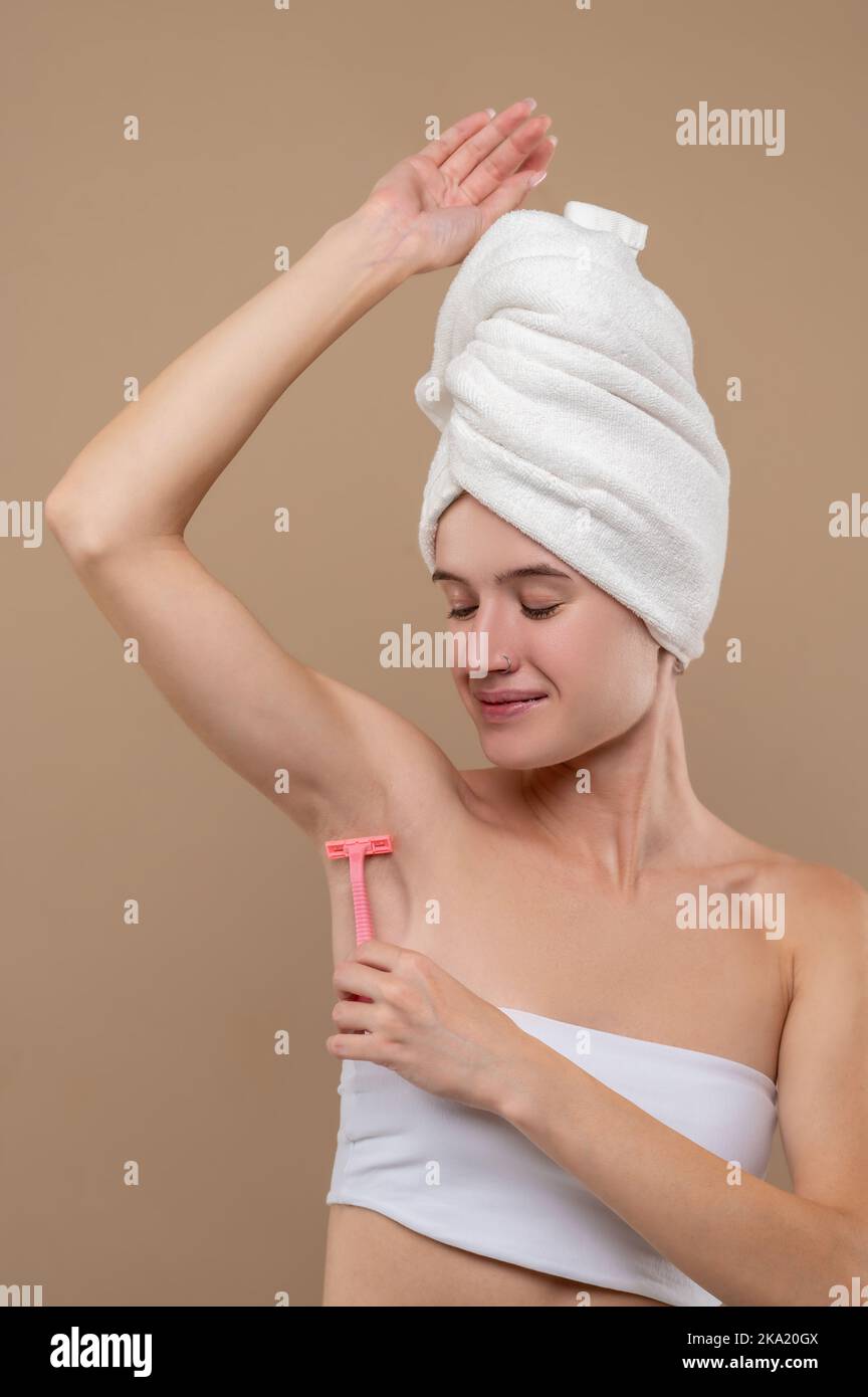 Young woman shaving underarms area Stock Photo - Alamy