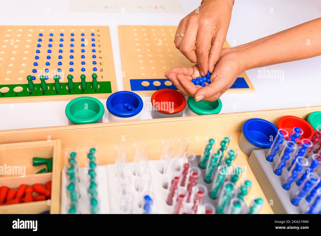 Detail of a montessori board division with the hand of a guide and ...