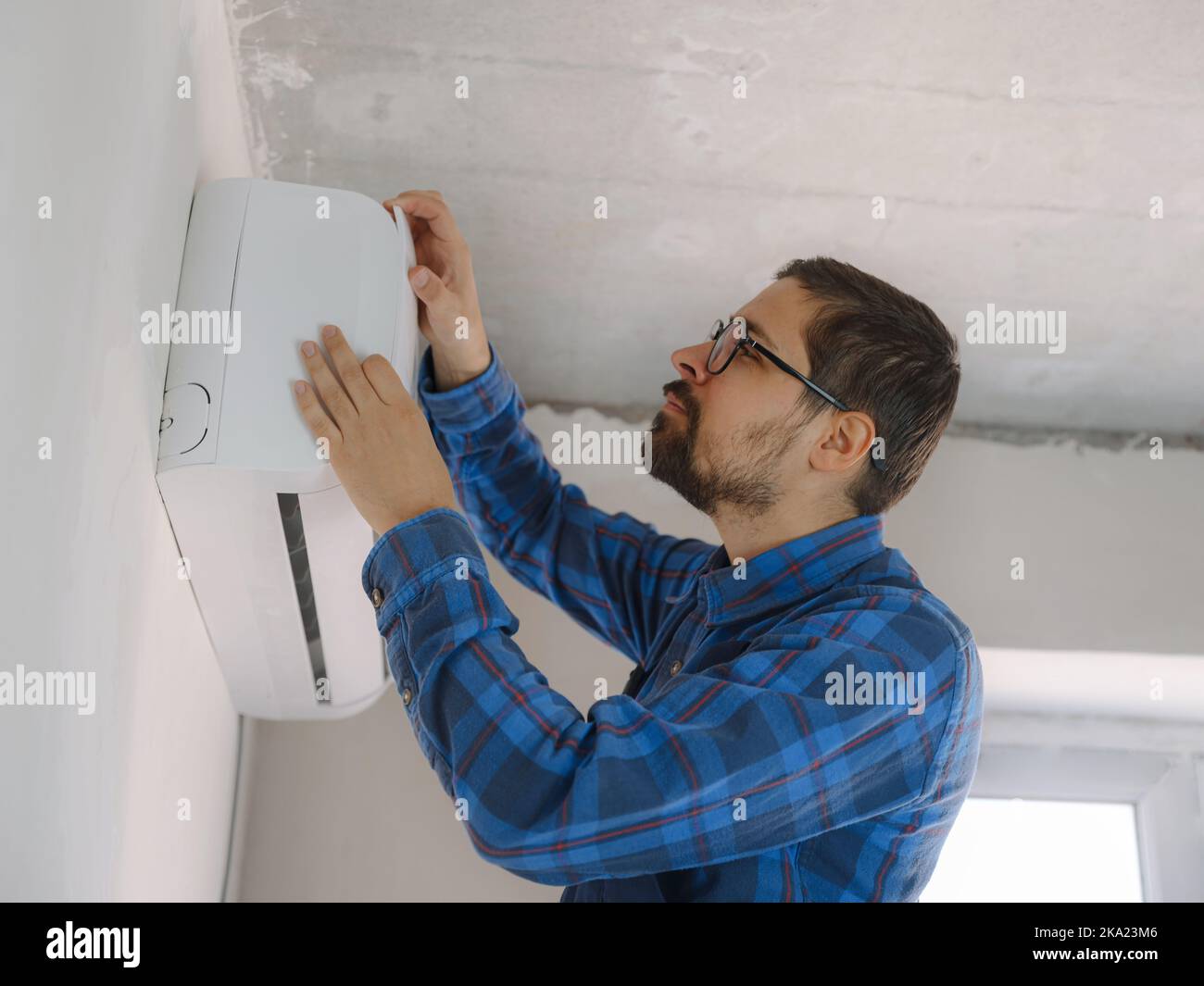 young man in blue work suit doing Repair apartment. Home renovation ...