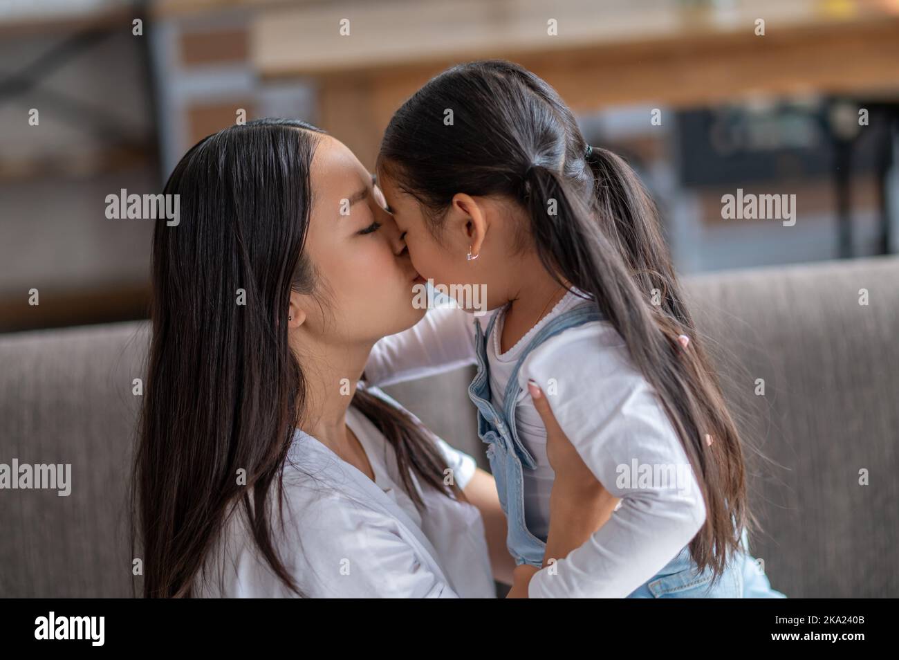 Affectionate female parent kissing her little daughter Stock Photo - Alamy