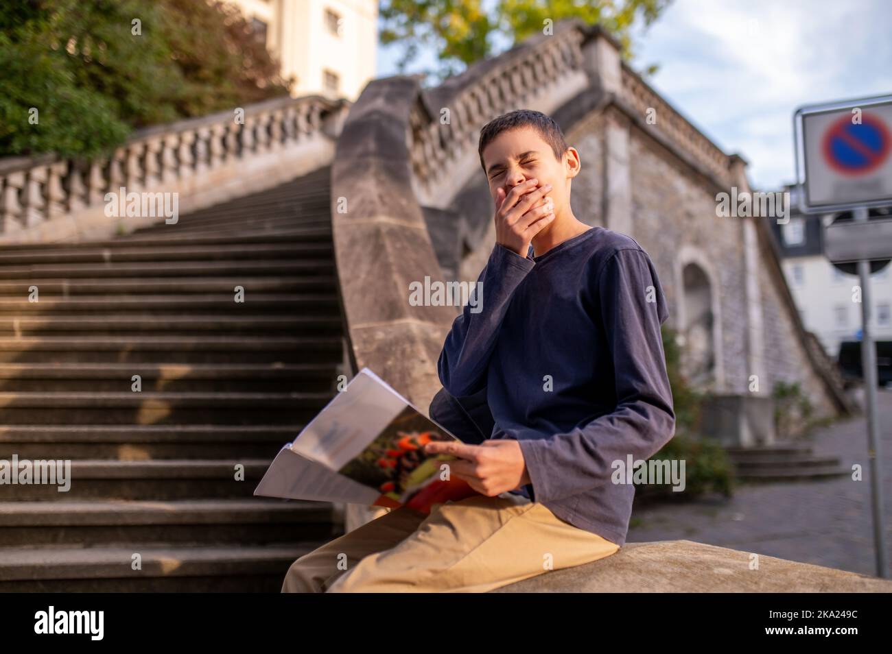 Adolescent boy feeling tired of reading a book Stock Photo - Alamy