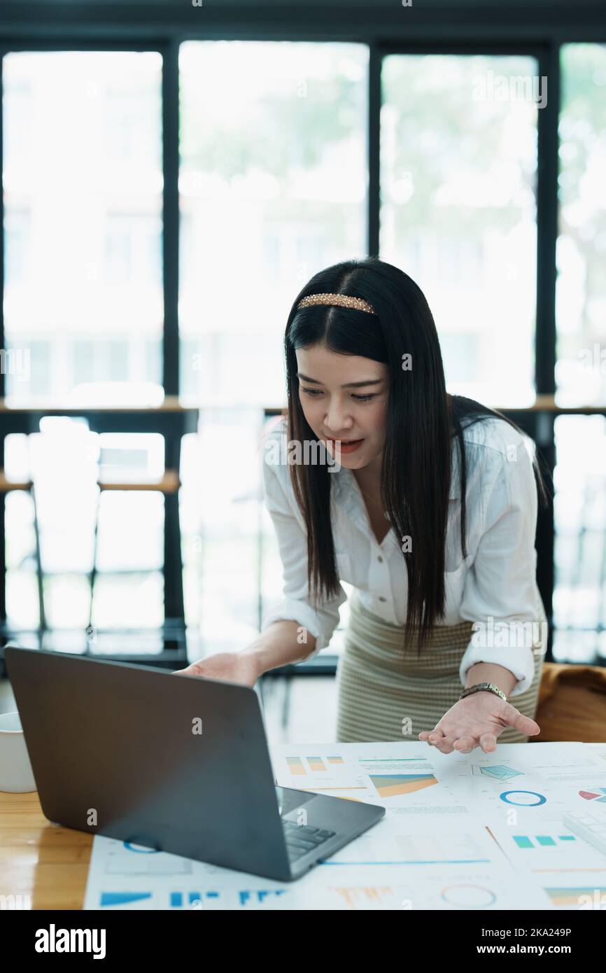 Portrait of a beautiful Asian teenage girl using computer for video ...