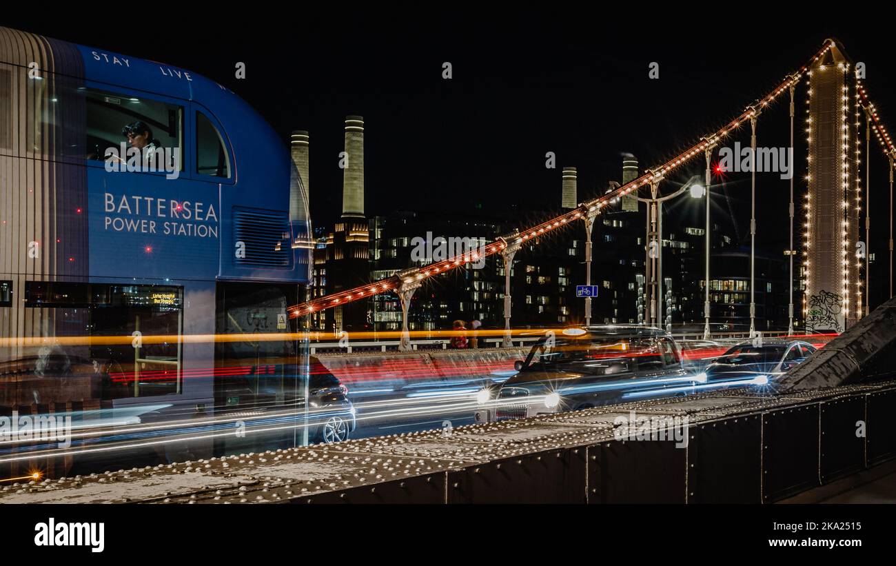 A London taxi amongst the traffic on Chelsea Bridge with an advert of ...