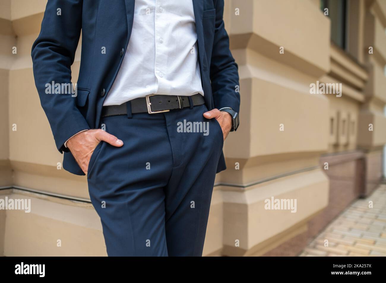 Elegant man standing near the wall of a big building Stock Photo - Alamy