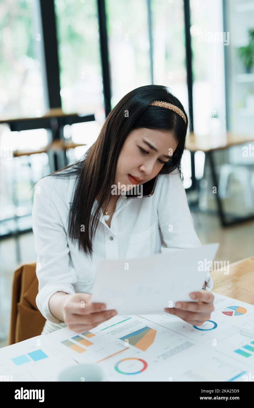 A portrait of a beautiful Asian female employee showing a stressed face ...