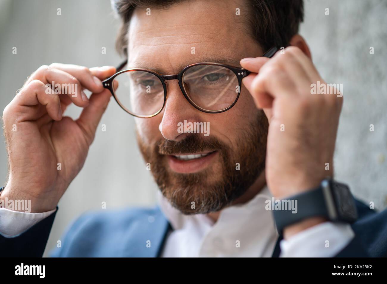 Headshot of a man putting on eyeglasses Stock Photo - Alamy