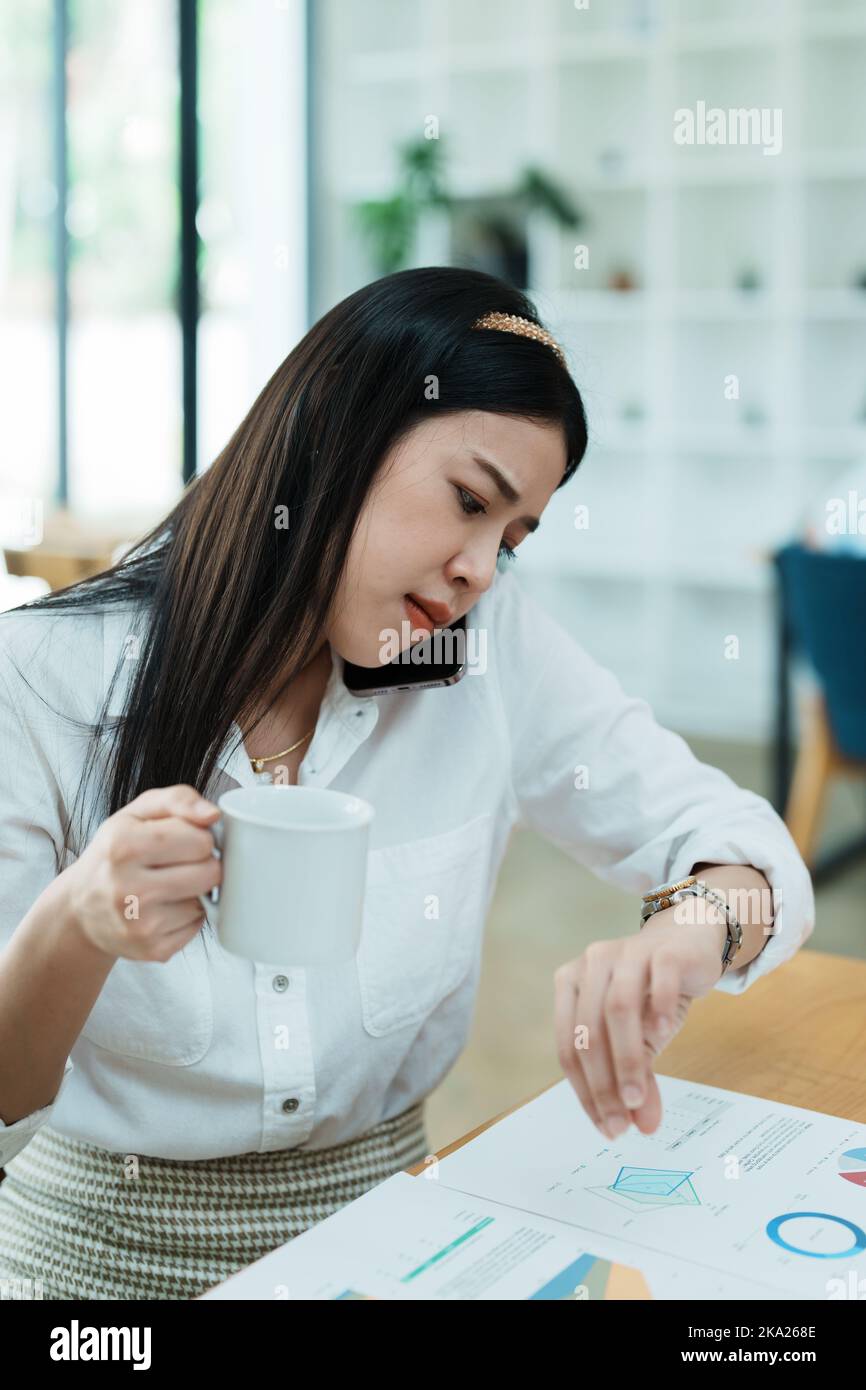 A portrait of a beautiful Asian employee hustle rushing while watch at ...