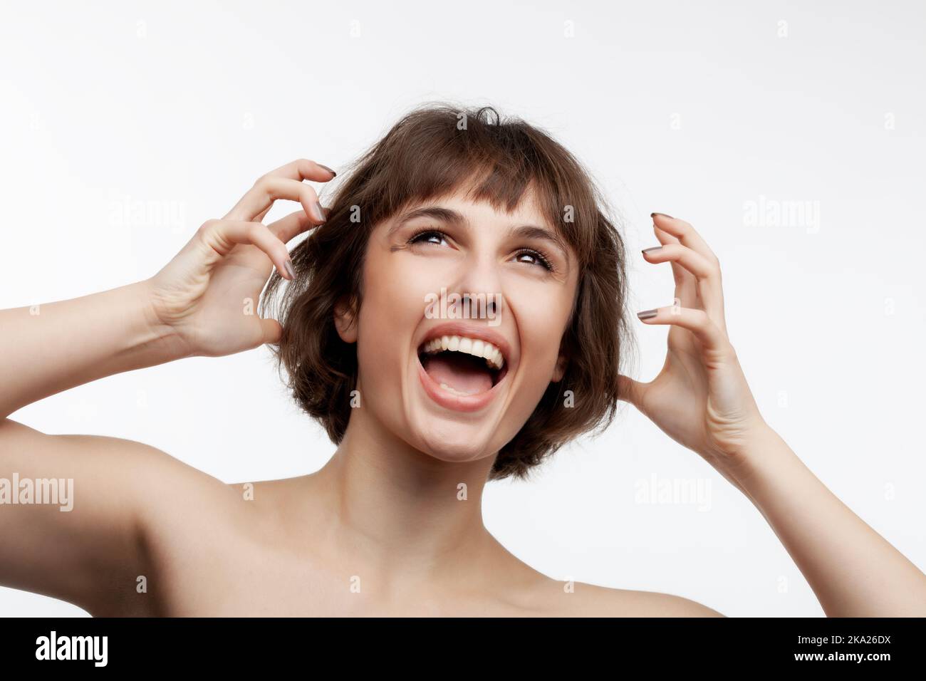 studio portrait of a screaming beautiful brunette girl with short hair ...