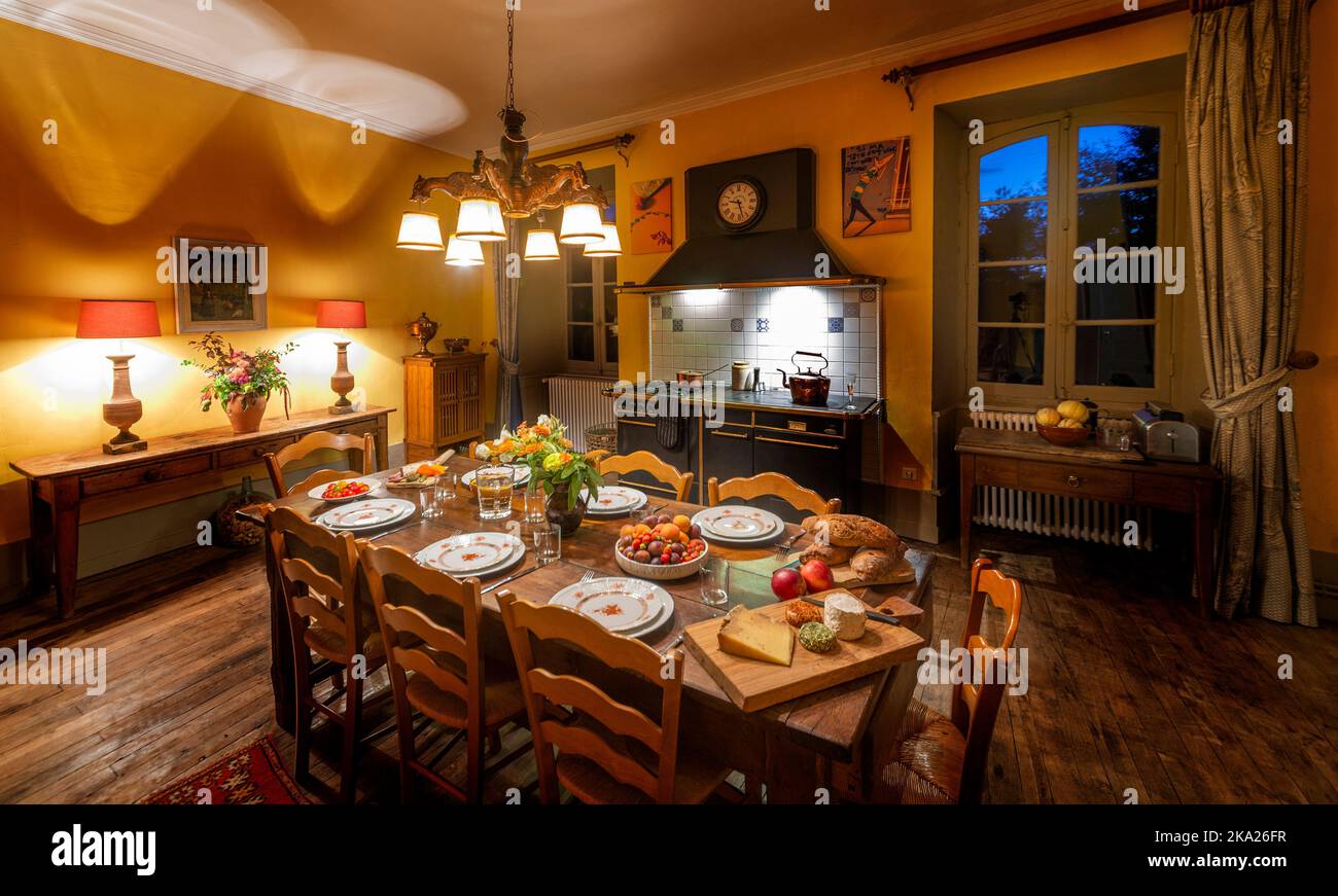 A French country estate kitchen with a laid table set ready for guests ...