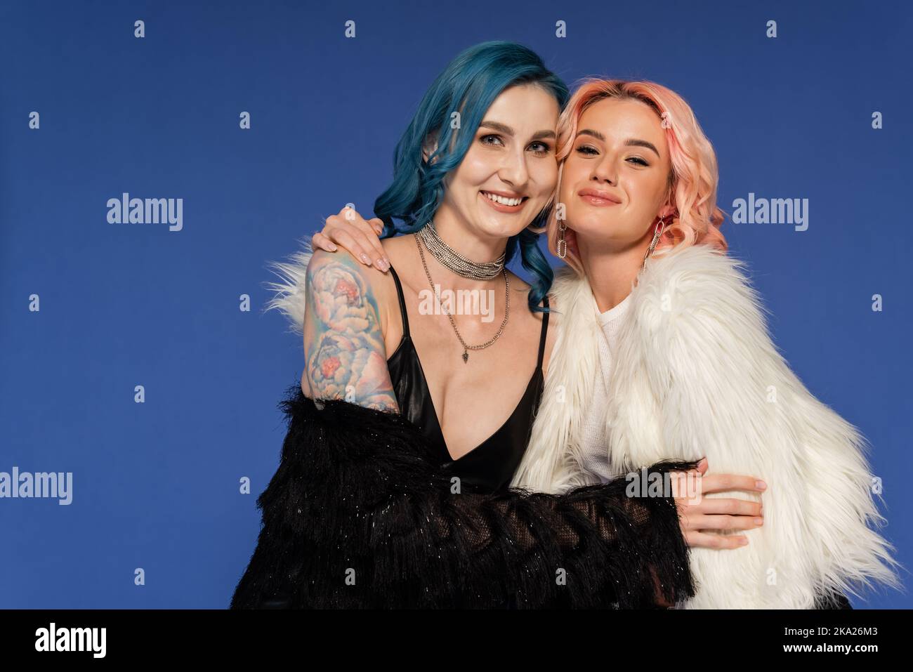 happy queer friends in black and white faux fur jackets smiling at ...