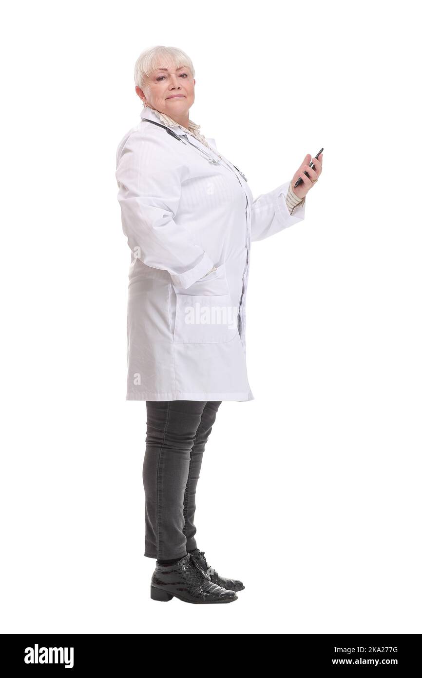 Side view of concentrated mature female doctor reading text message ...