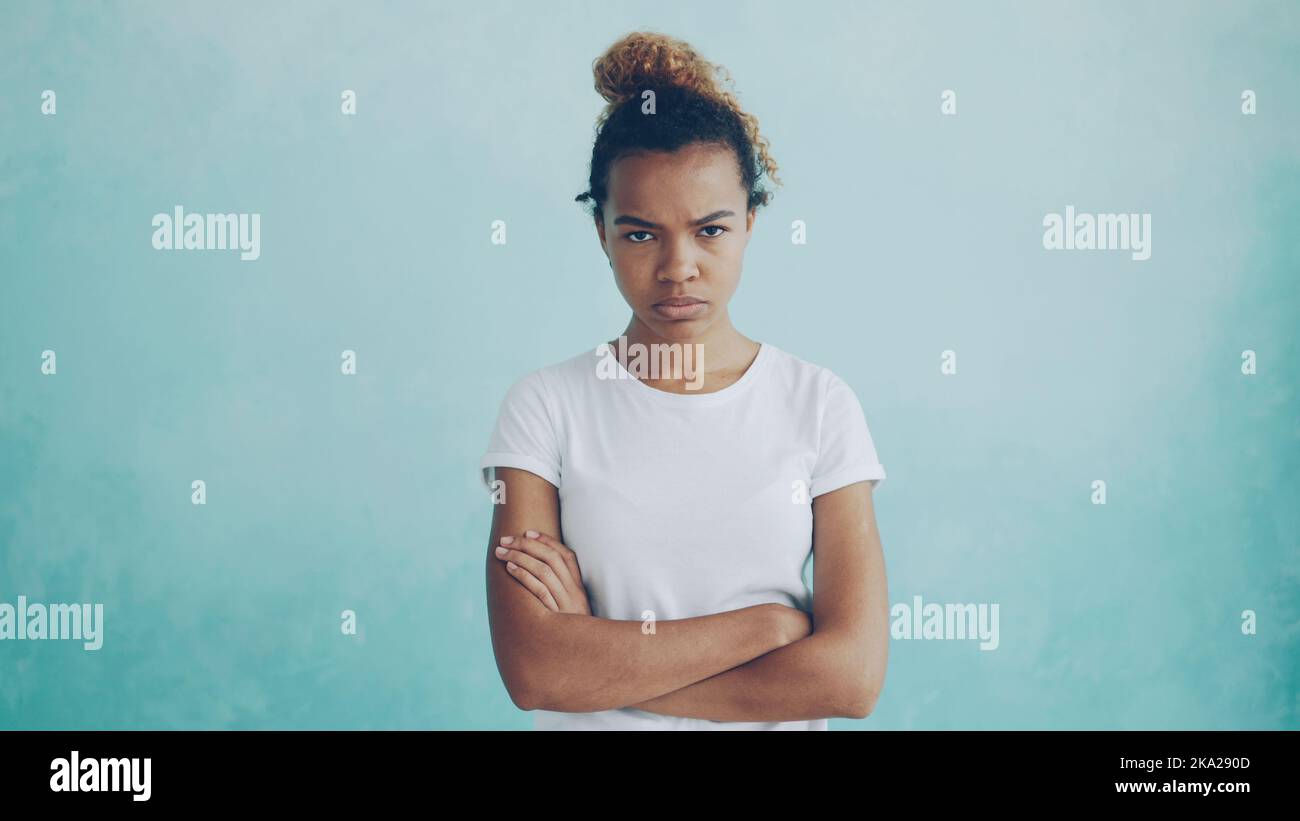 Portrait of angry African American lady looking at camera, frowning and ...