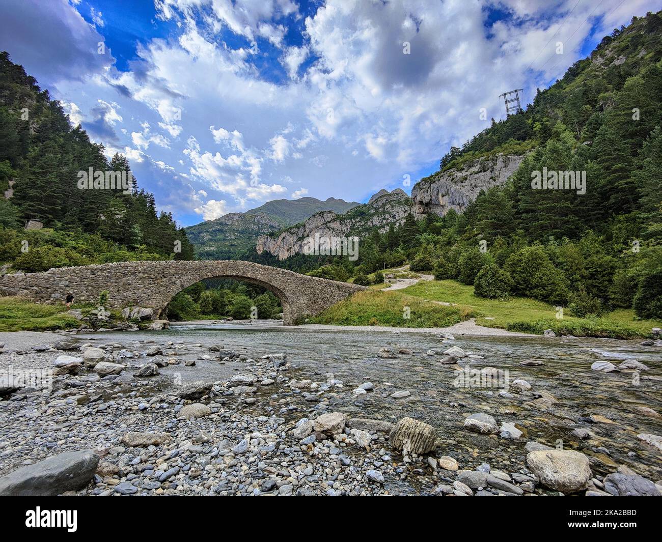A beautiful view of a stone bridge over the river with stones in a ...