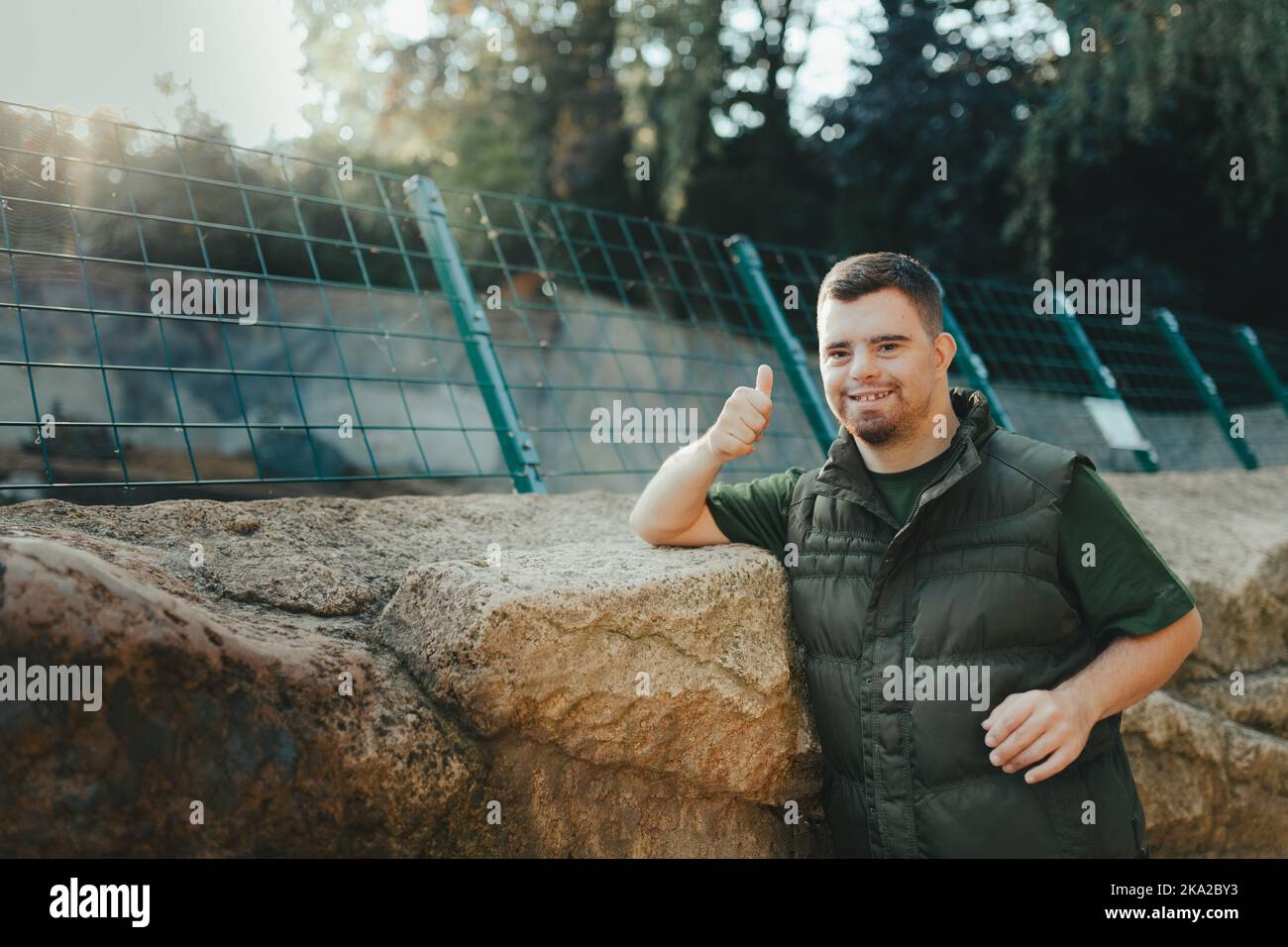Portrait of caretaker with down syndrome in zoo. Concept of integration ...