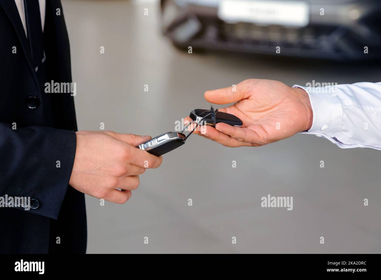Car salesman gives the keys to the customers who signed the purchase ...