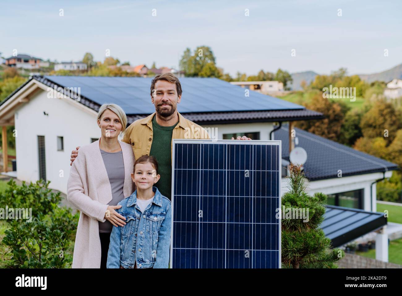 Happy family near their house with solar panel. Alternative energy ...