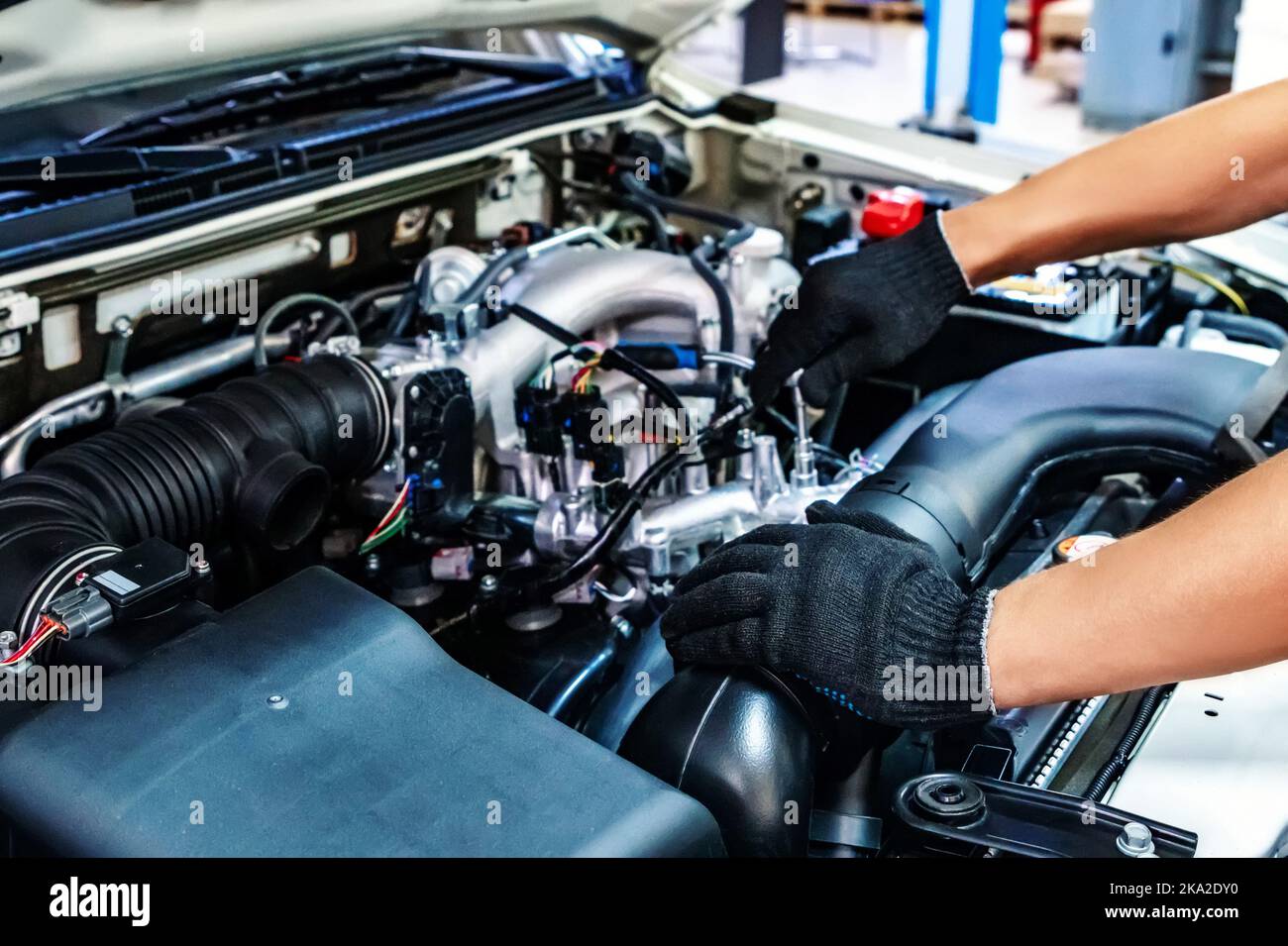 Auto mechanic working with open car hood in garage. Car repair service ...