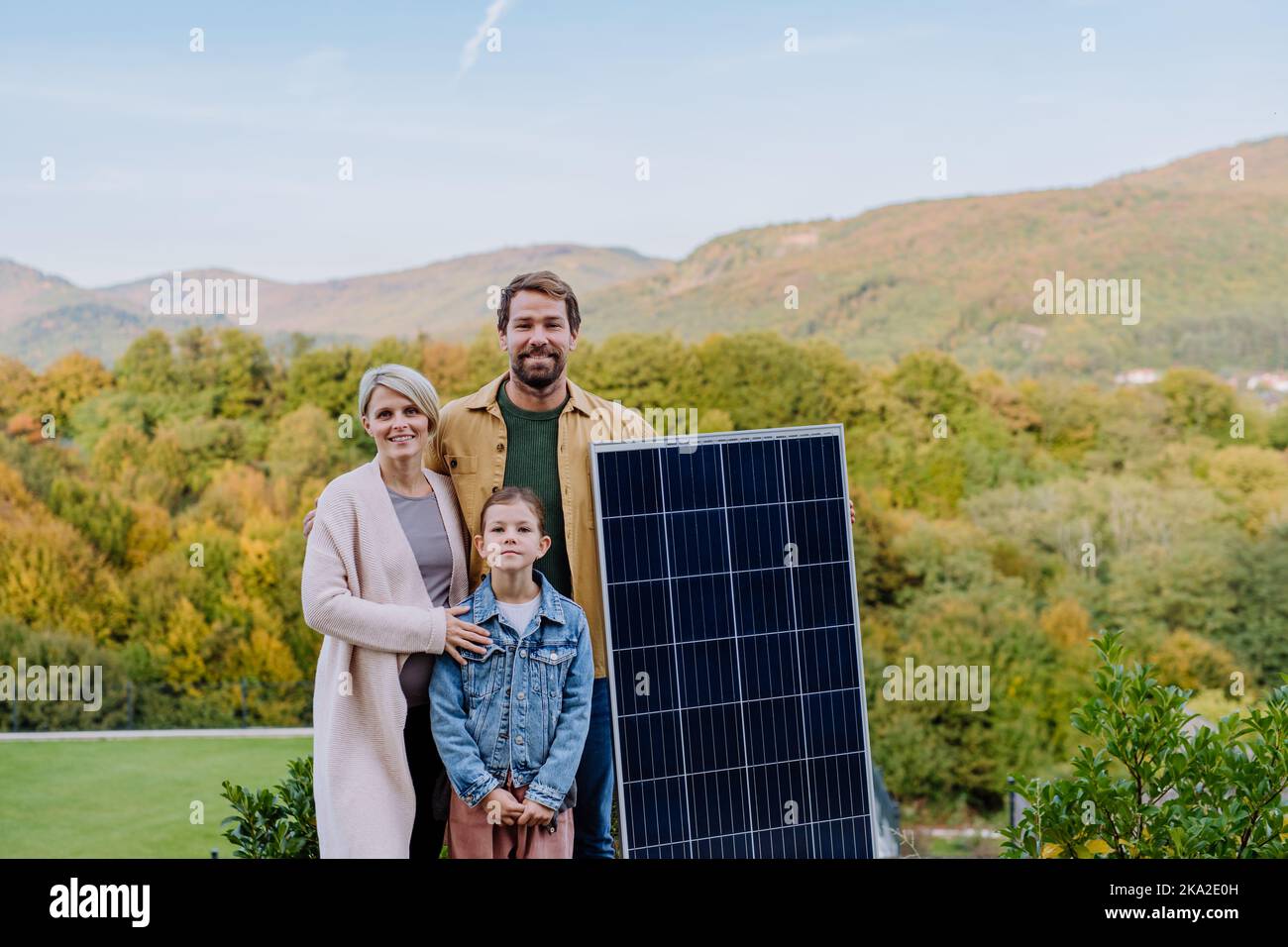 Happy family near their house with solar panel. Alternative energy ...