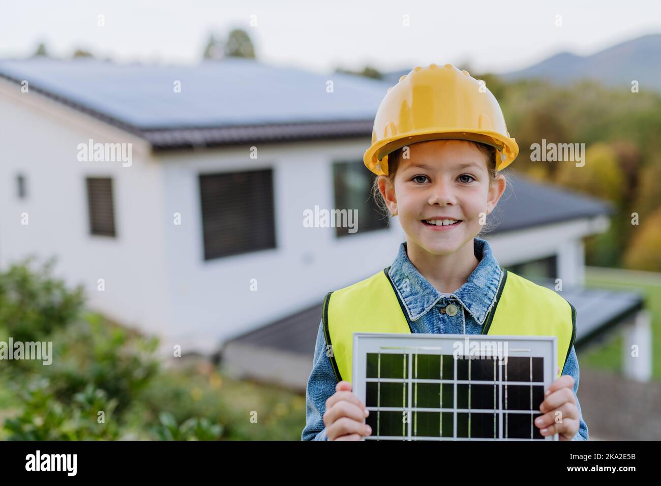 Little girl with protective helmet and reflective vest holding ...