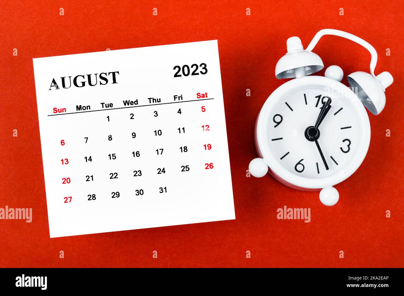August 2023 Monthly calendar year with alarm clock on red background ...