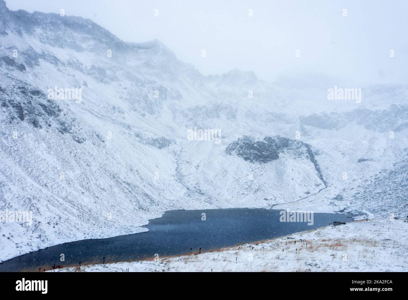 The snowy mountains of the Alps mountain range surrounding a lake in ...