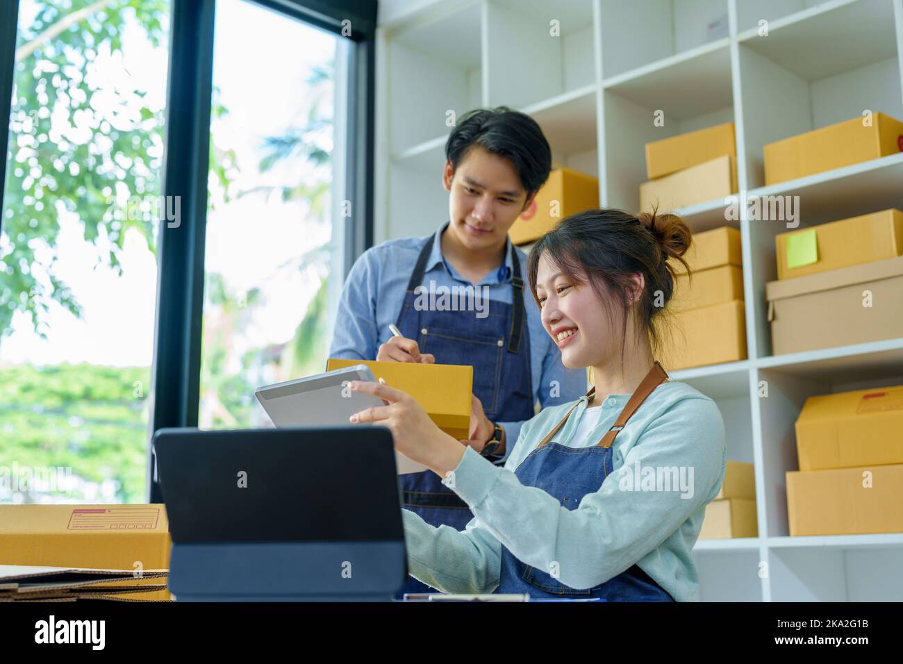 Portrait of a small start-up and SME owner, an Asian male and female ...