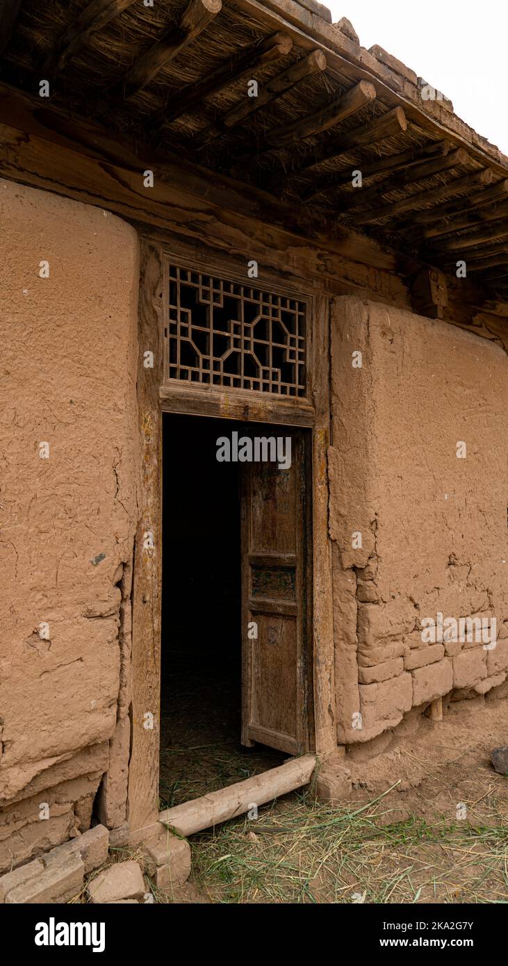 A vertical of the door of an old mud brick house in a village with poor ...