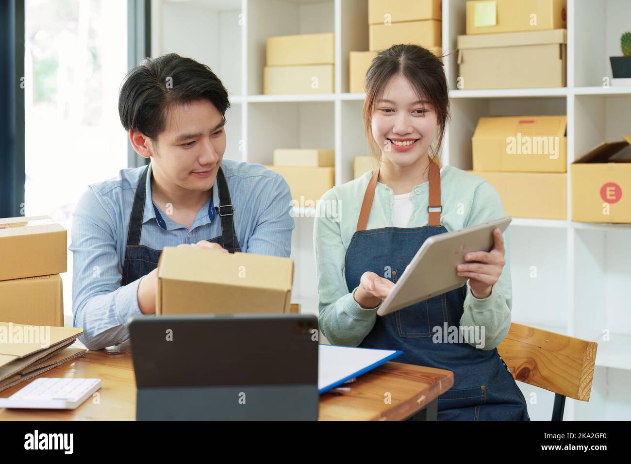 Portrait of a small start-up and SME owner, an Asian male and female ...